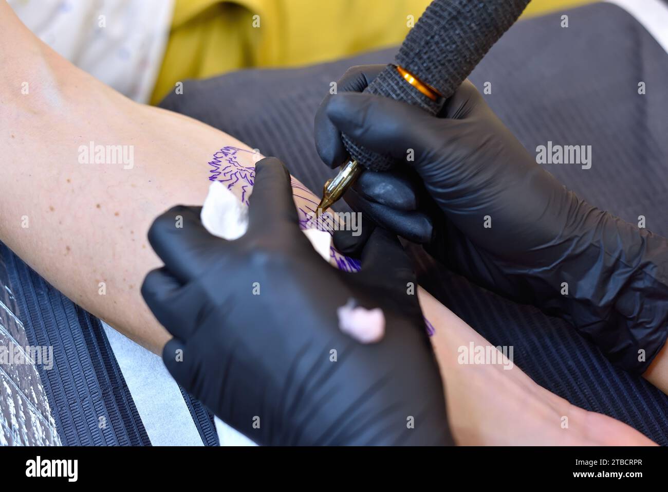 Tattoo artist creating tattoo on hand. Art and design concept. Close up ...