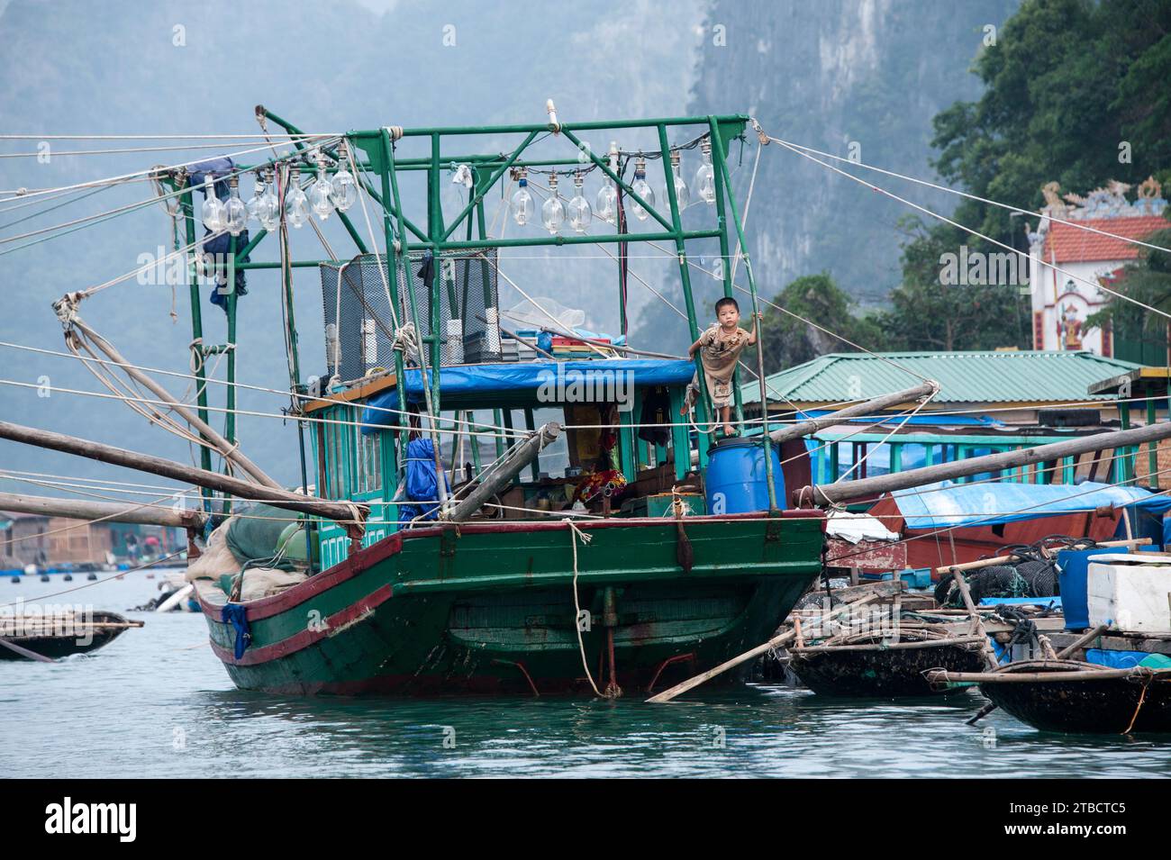 Fishing boat in a floating village of Halong Bay Stock Photo - Alamy