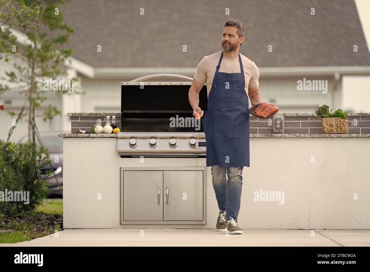 photo of man cook seafood barbecue with fish, advertisement. man cook ...