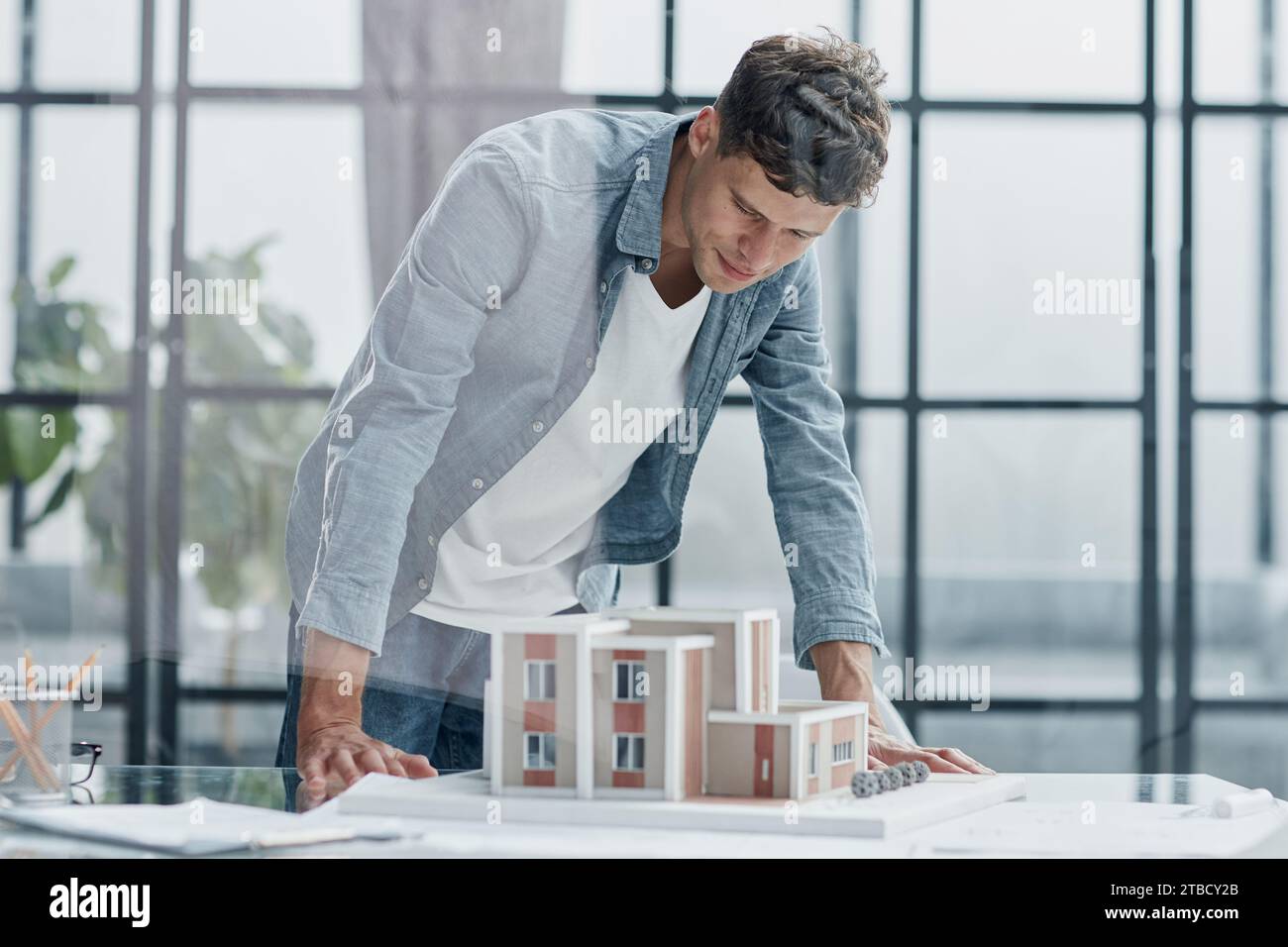 male architect designer examines the layout of the house. new project ...