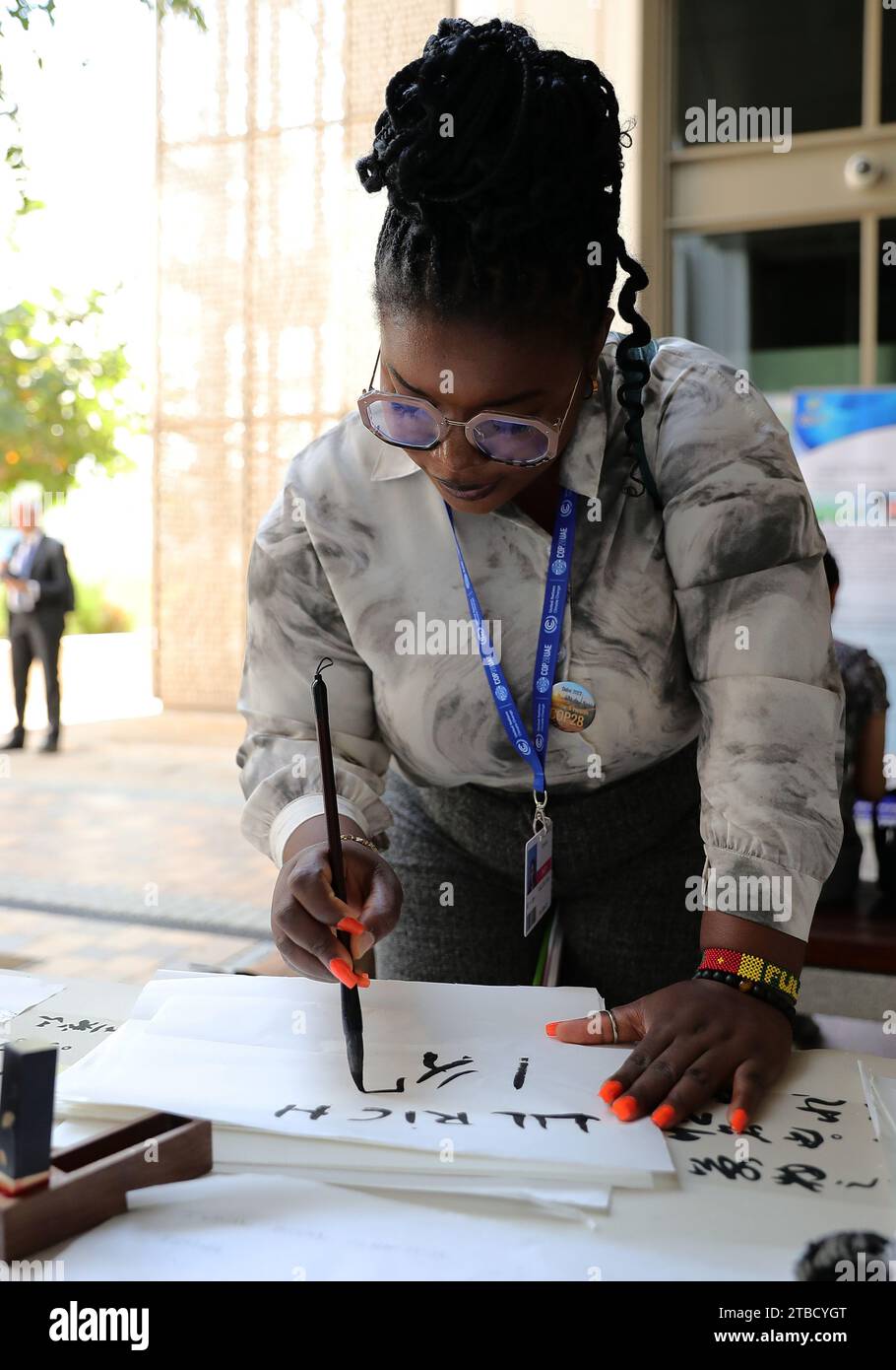 Dubai, UAE. 06th Dec, 2023. An attendee experiences Chinese calligraphy ...