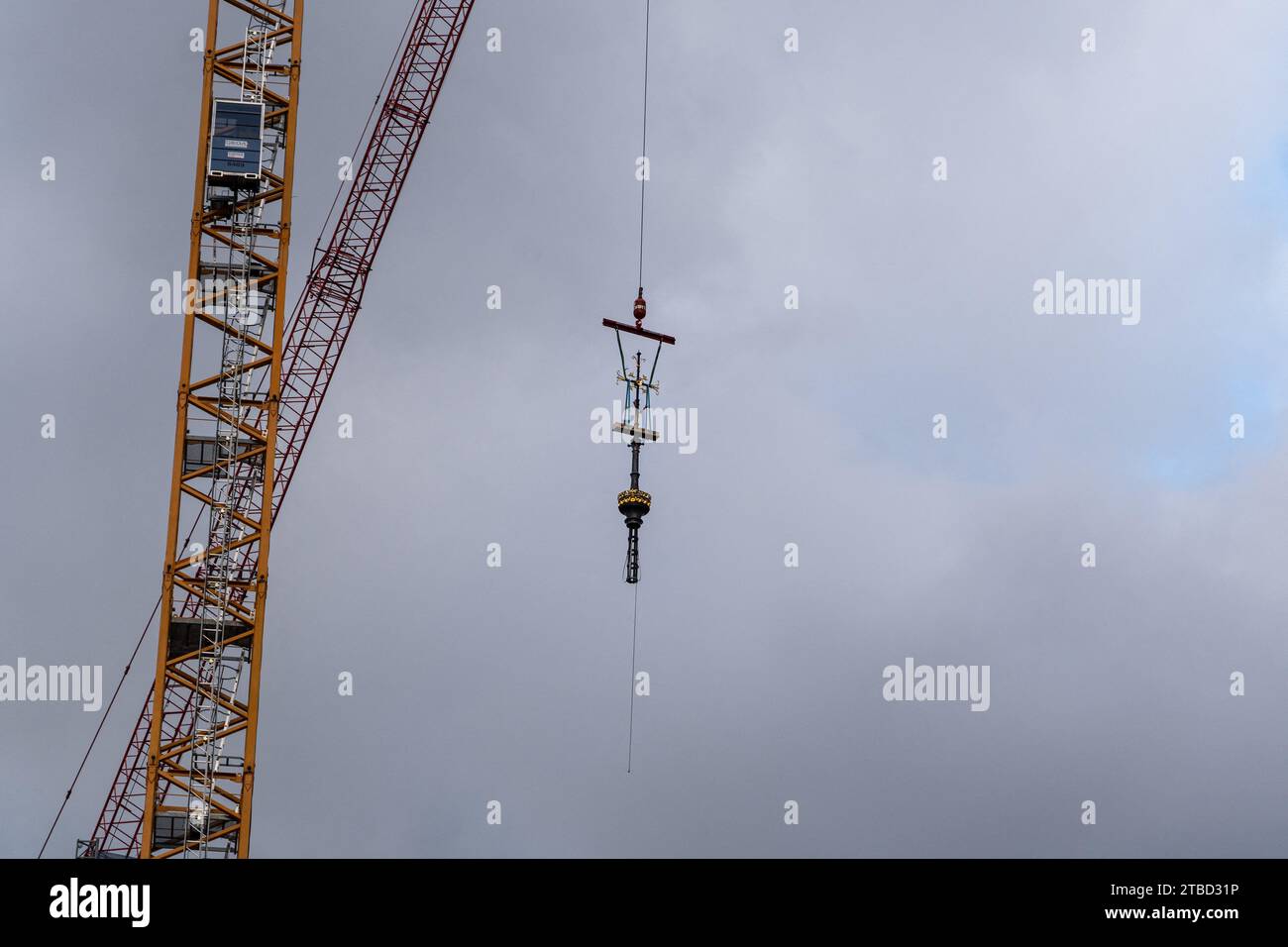 Paris, France. 06th Dec, 2023. Workers place the cross atop the newly ...