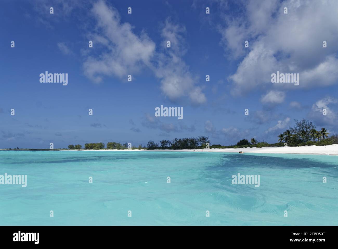 White beach, turquoise blue water, blue sky with small clouds ...