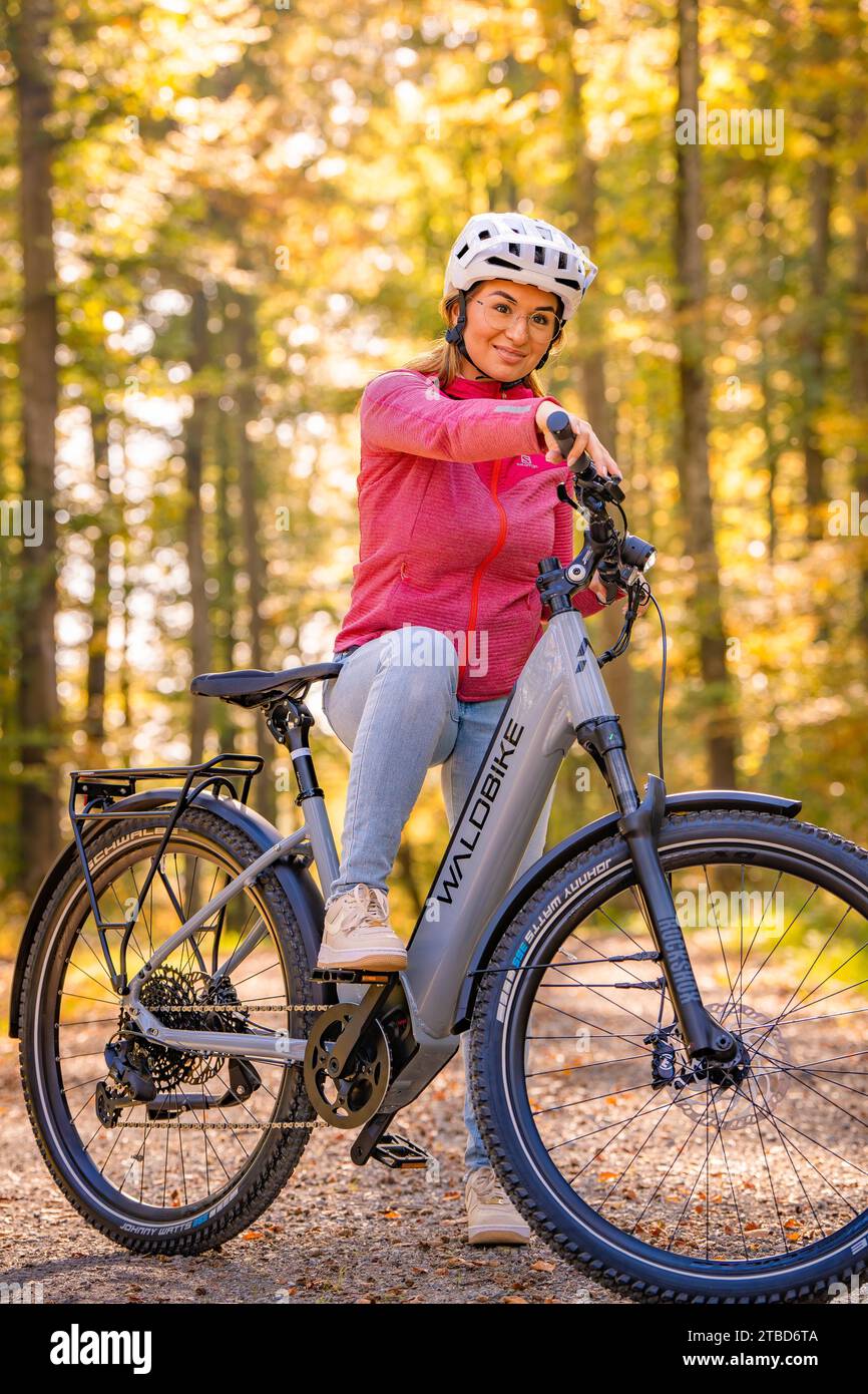Woman sitting on Ebike through autumn forest, Black Forest, Gechingen, Germany Stock Photo - Alamy