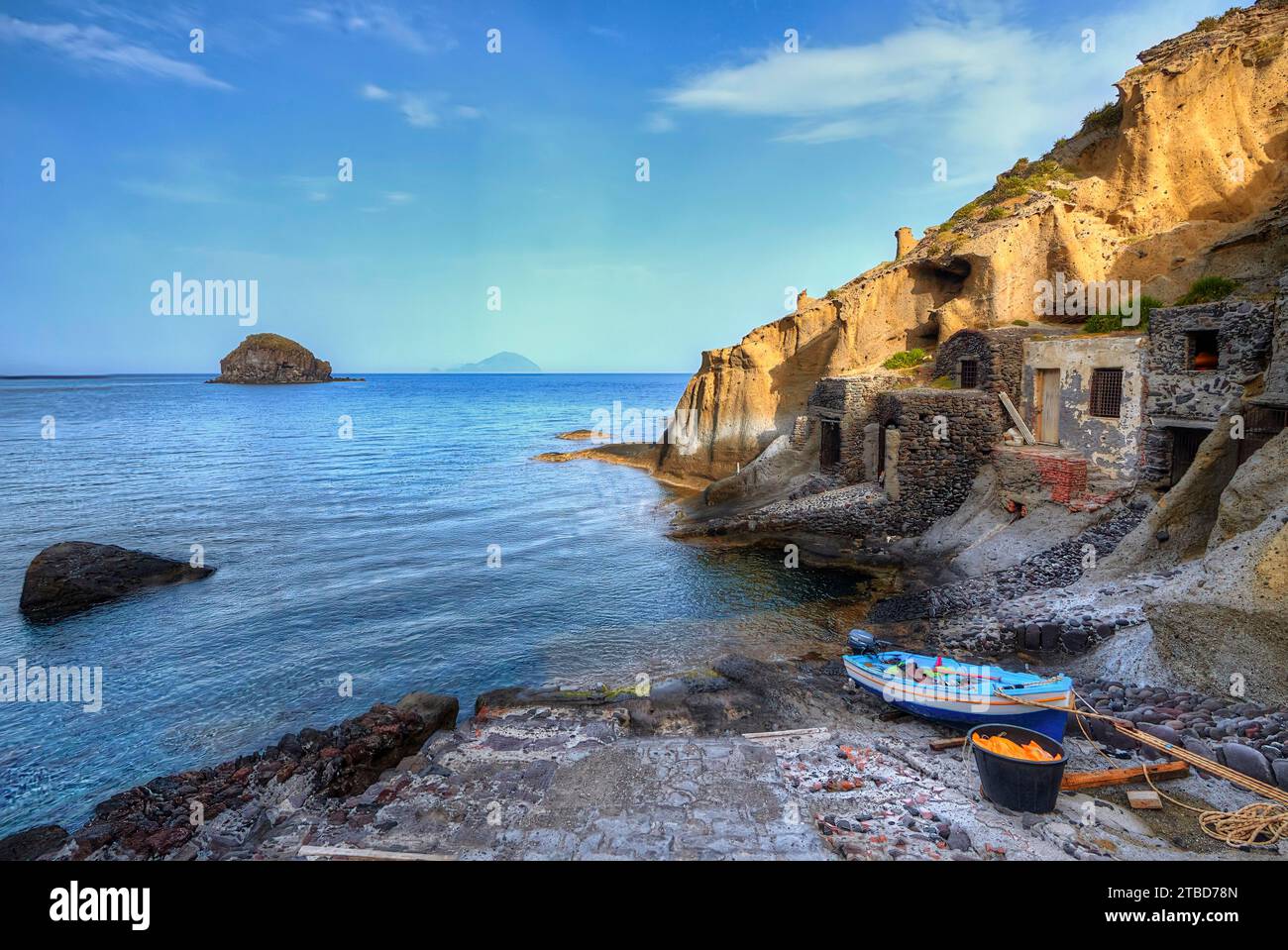 Houses in the rock, pebble beach, boat, sandstone rocks, Filicudi ...