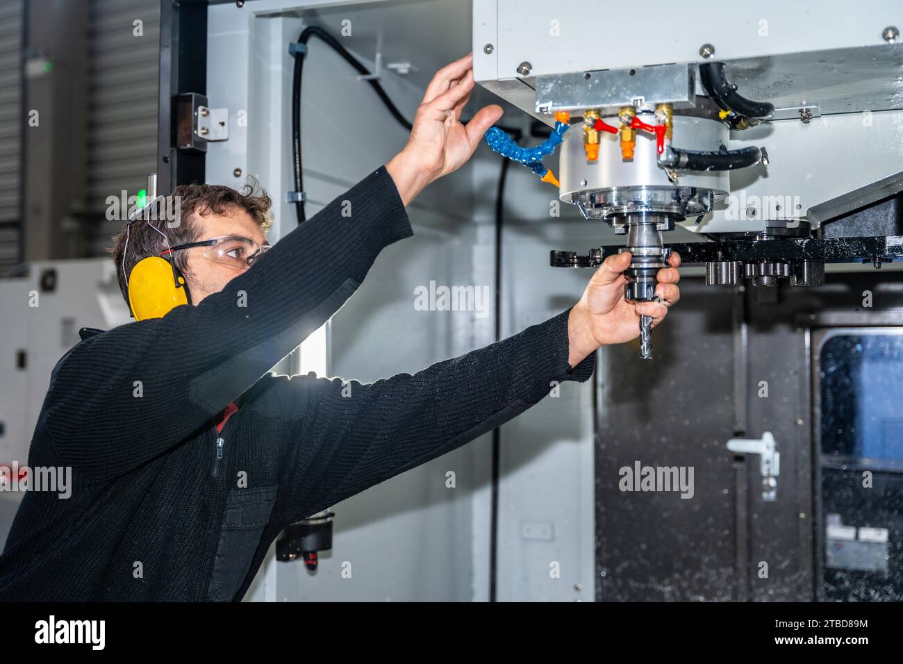 Manual worker placing a lathe in the milling machine in a cnc modern ...
