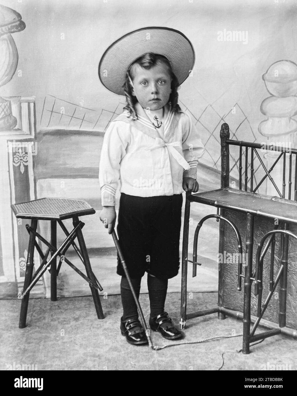 Edwardian formal portrait of a young girl standing, holding a whip ...