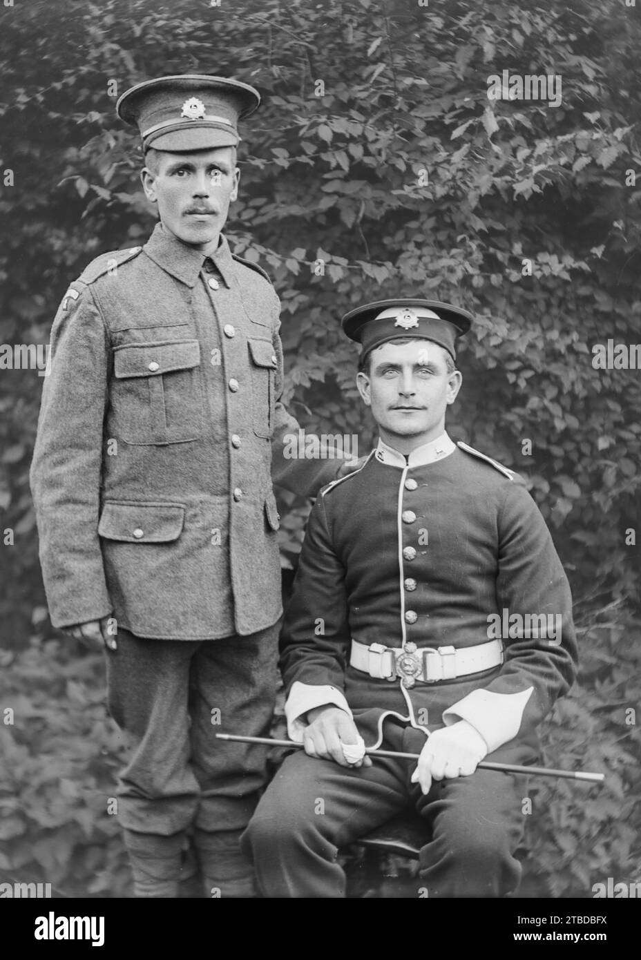 Edwardian casual portrait of two men in uniform, outside, one sitting ...