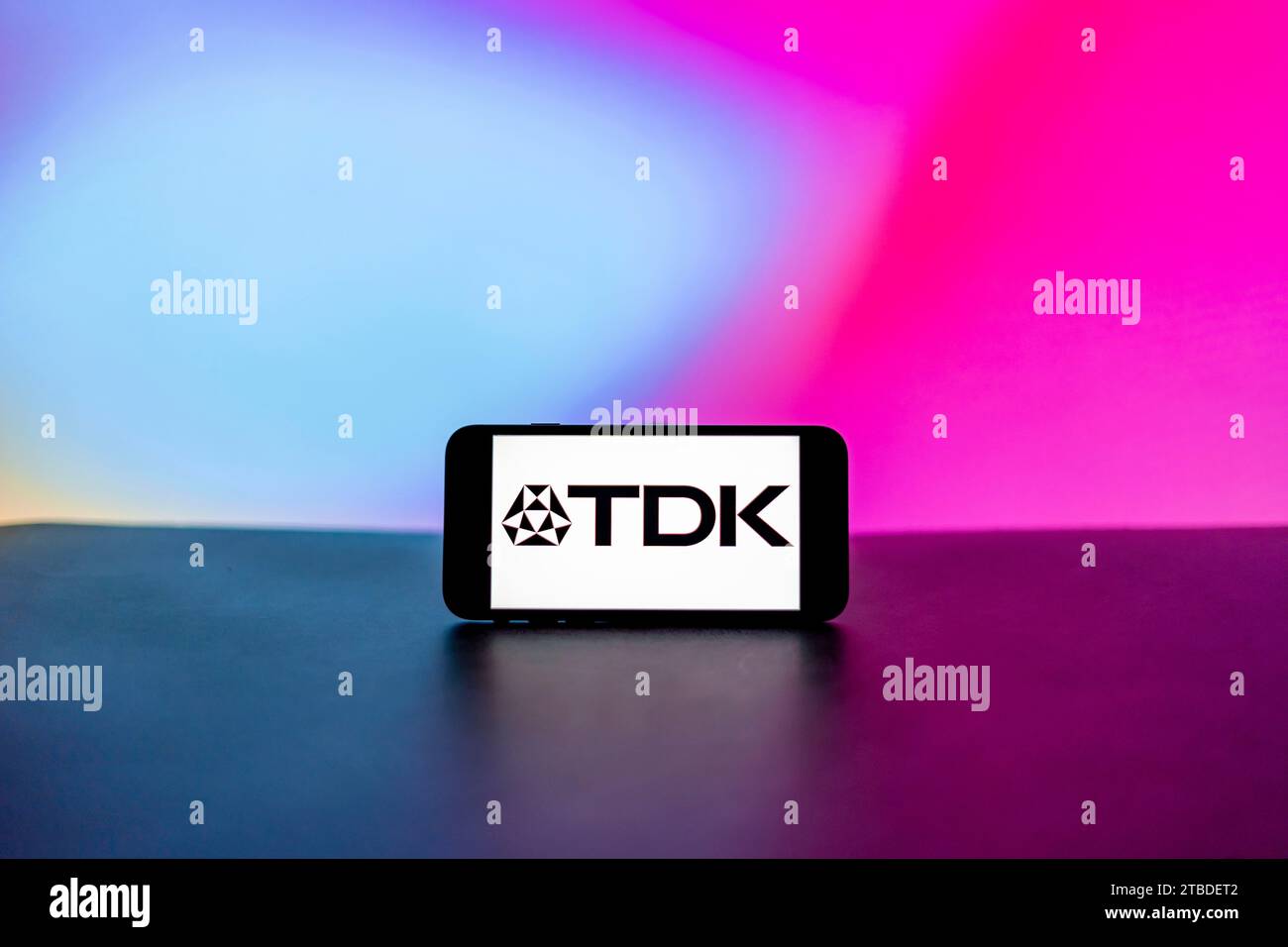 In this photo illustration, a TDK logo is seen displayed on a mobile ...