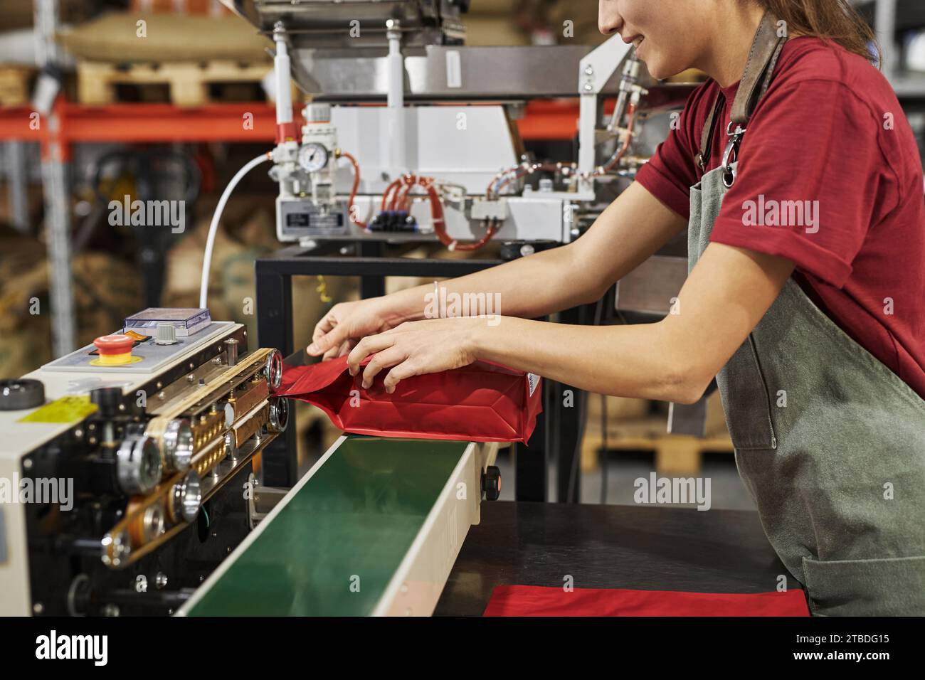 Side view close up of young woman sealing plastic bags while working on ...