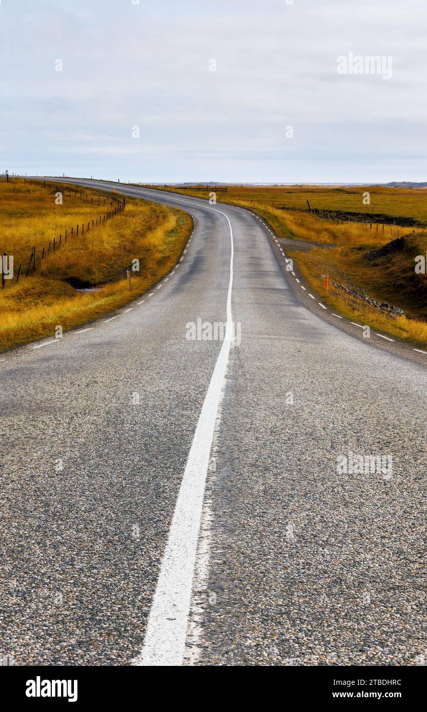 A scenic country road stretches across the horizon of a vast, open ...