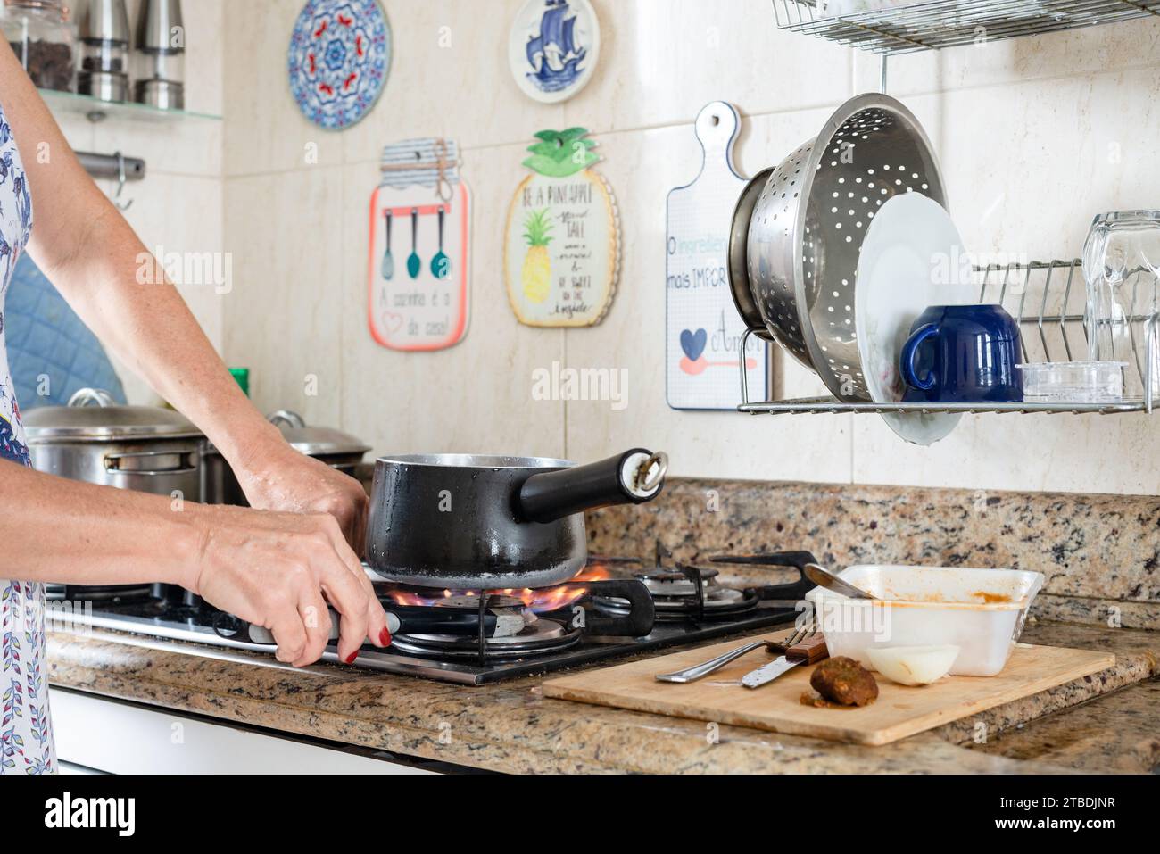 Pan being placed on the stove to cook. Healthy food Stock Photo - Alamy