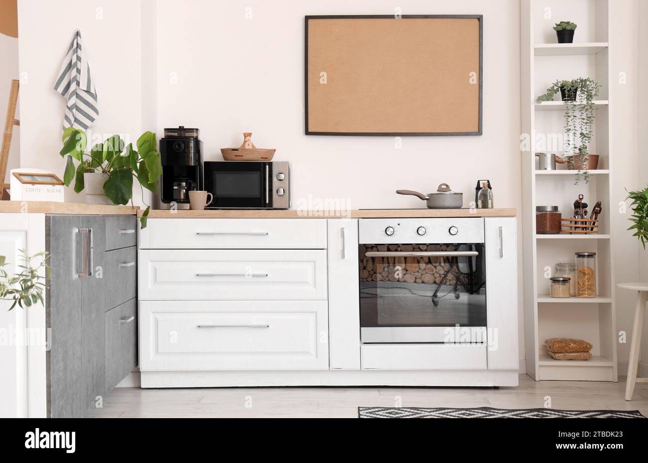 Interior of light kitchen with counters and shelf unit Stock Photo - Alamy