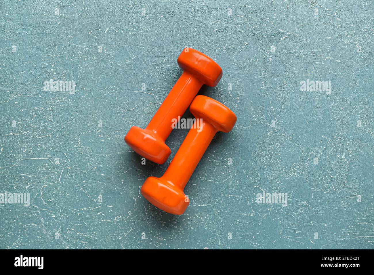 Orange dumbbells on blue background Stock Photo - Alamy