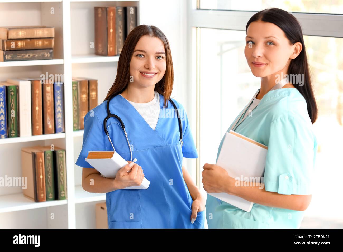 Female medical students with books in library Stock Photo - Alamy