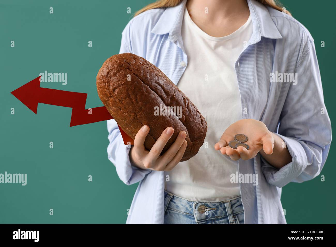 Young woman with arrow, bread and coins on green background, closeup ...