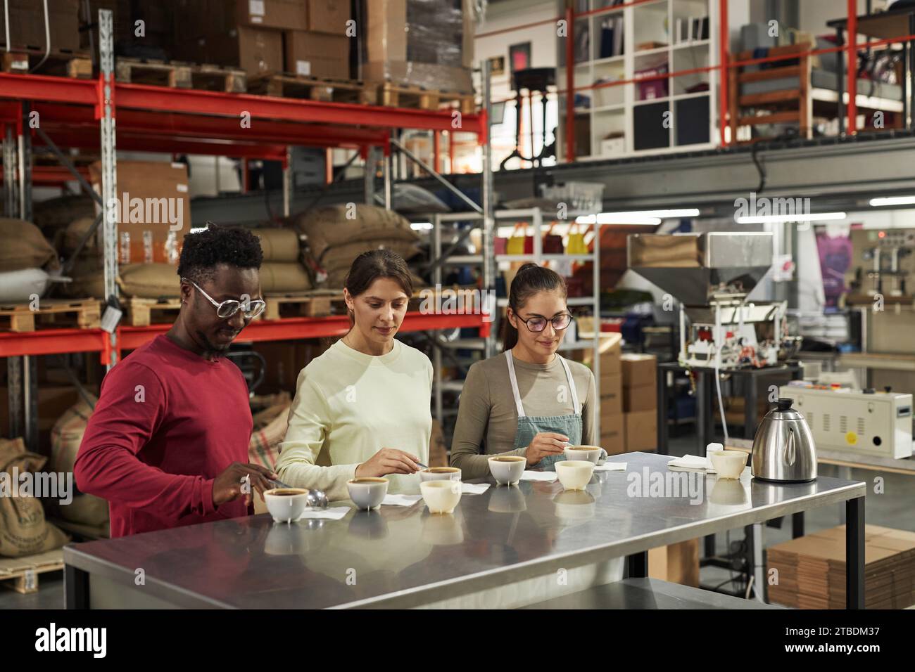 Diverse group of three young experts inspecting coffee quality during ...