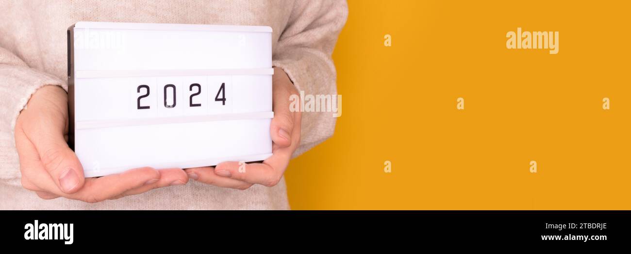 Banner with woman hold in hands lightbox with 2024 numbers in front of ...