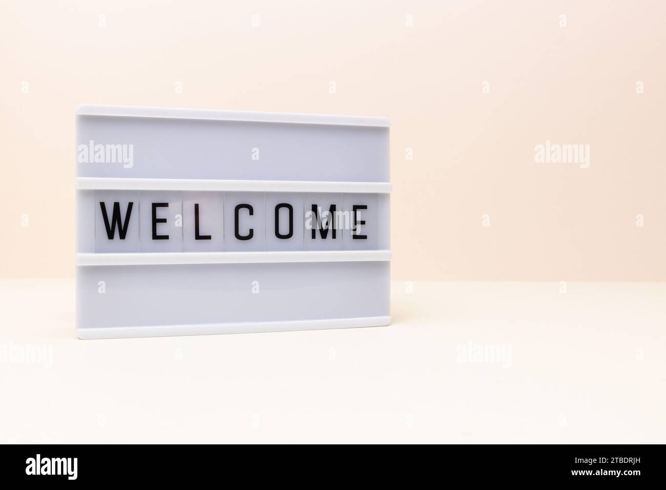 Word Welcome. Lightbox with letters in front of beige background ...