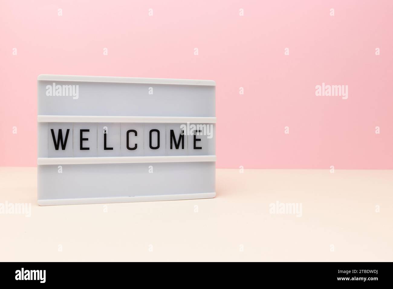 Word Welcome. Lightbox with letters in front of pink background. Place ...
