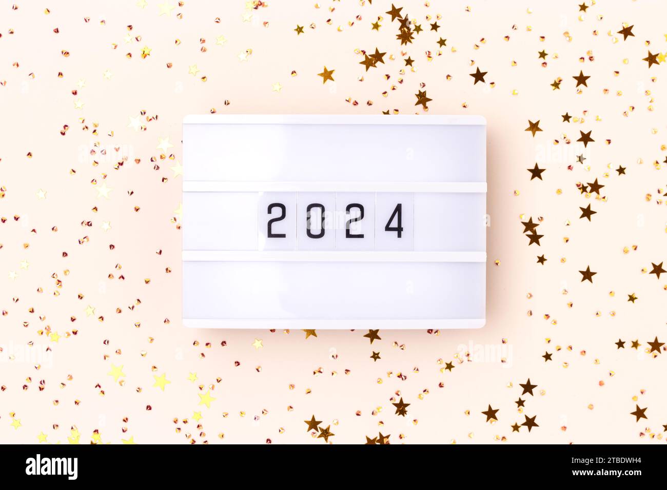 Lightbox with 2024 numbers and golden glittering stars confetti ...