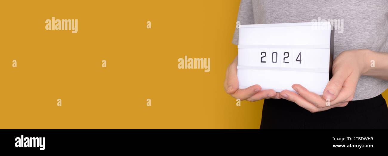 Banner with female hands hold lightbox with 2024 numbers in front of ...
