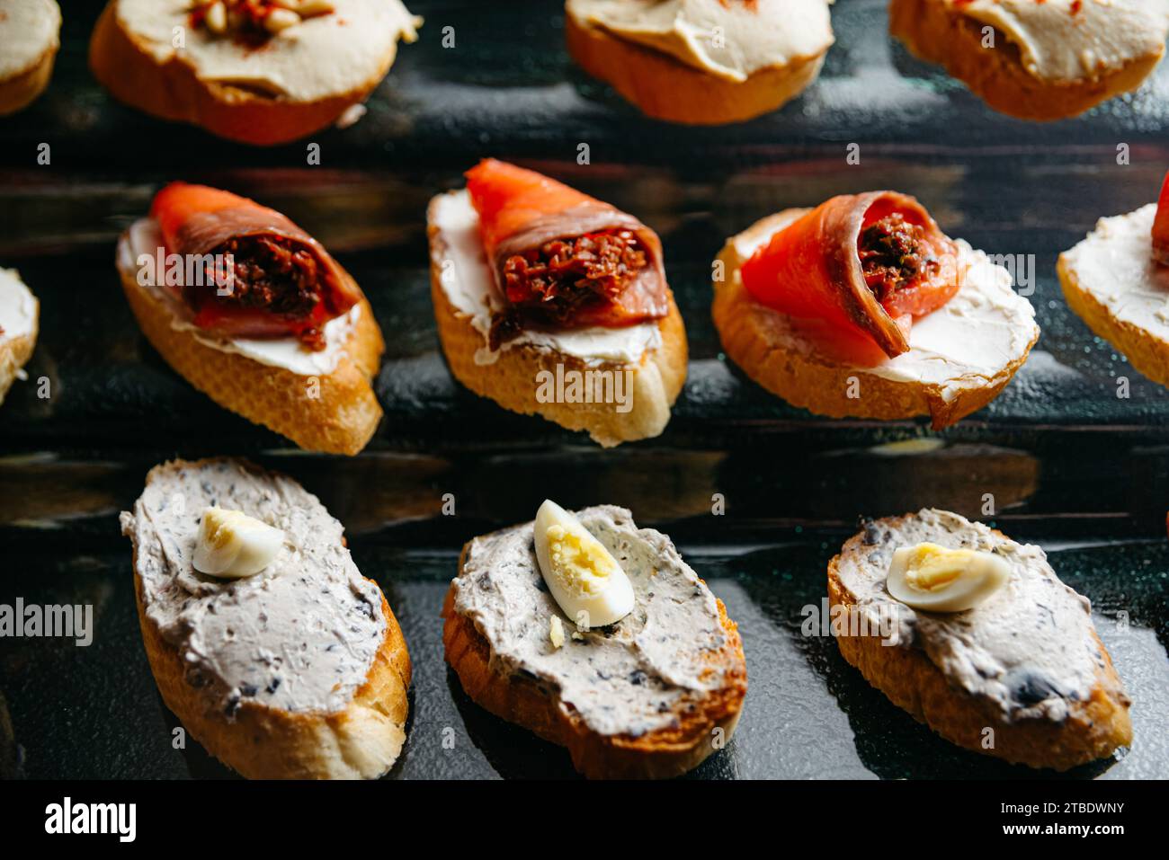 A close up of a bunch of appetizers on a glass stand. Crostini with ...