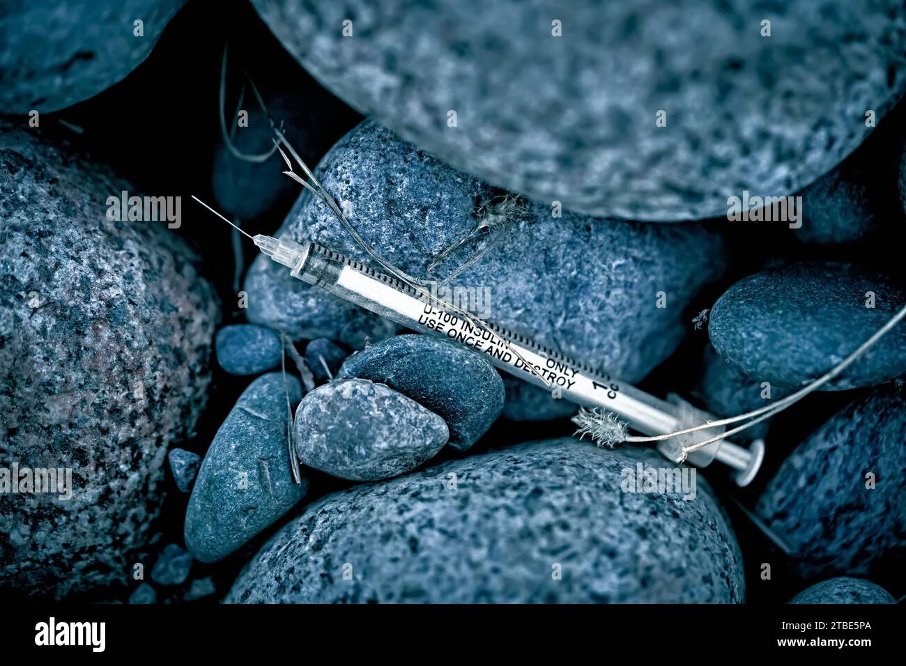 Used syringe lying on the ground Stock Photo - Alamy