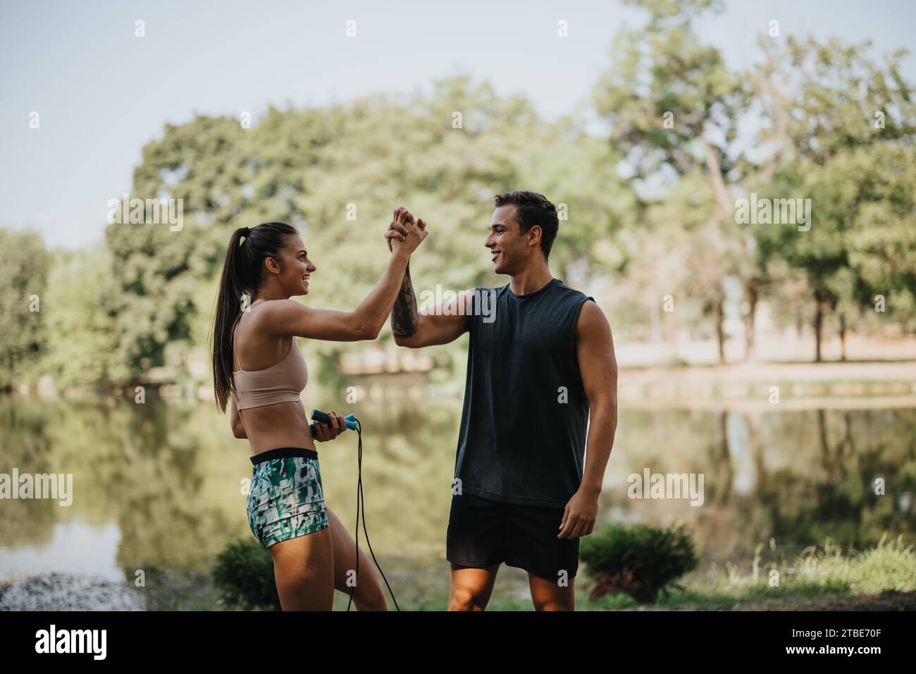 Two friends challenge themselves with jumping rope in a park, embracing ...