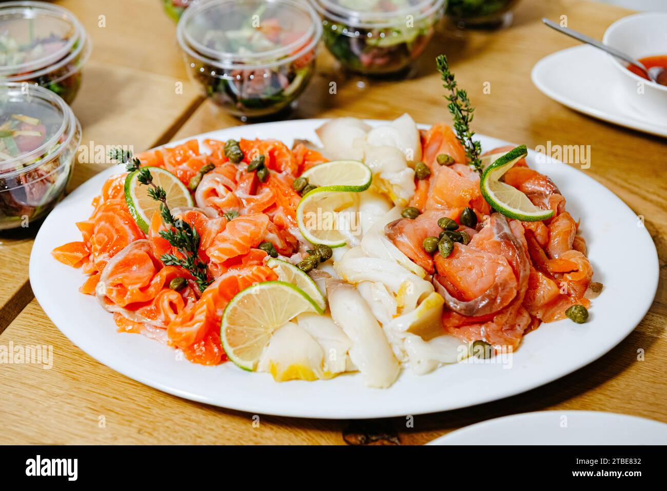 A gourmet platter of smoked salmon, white fish, capers, and lime ...