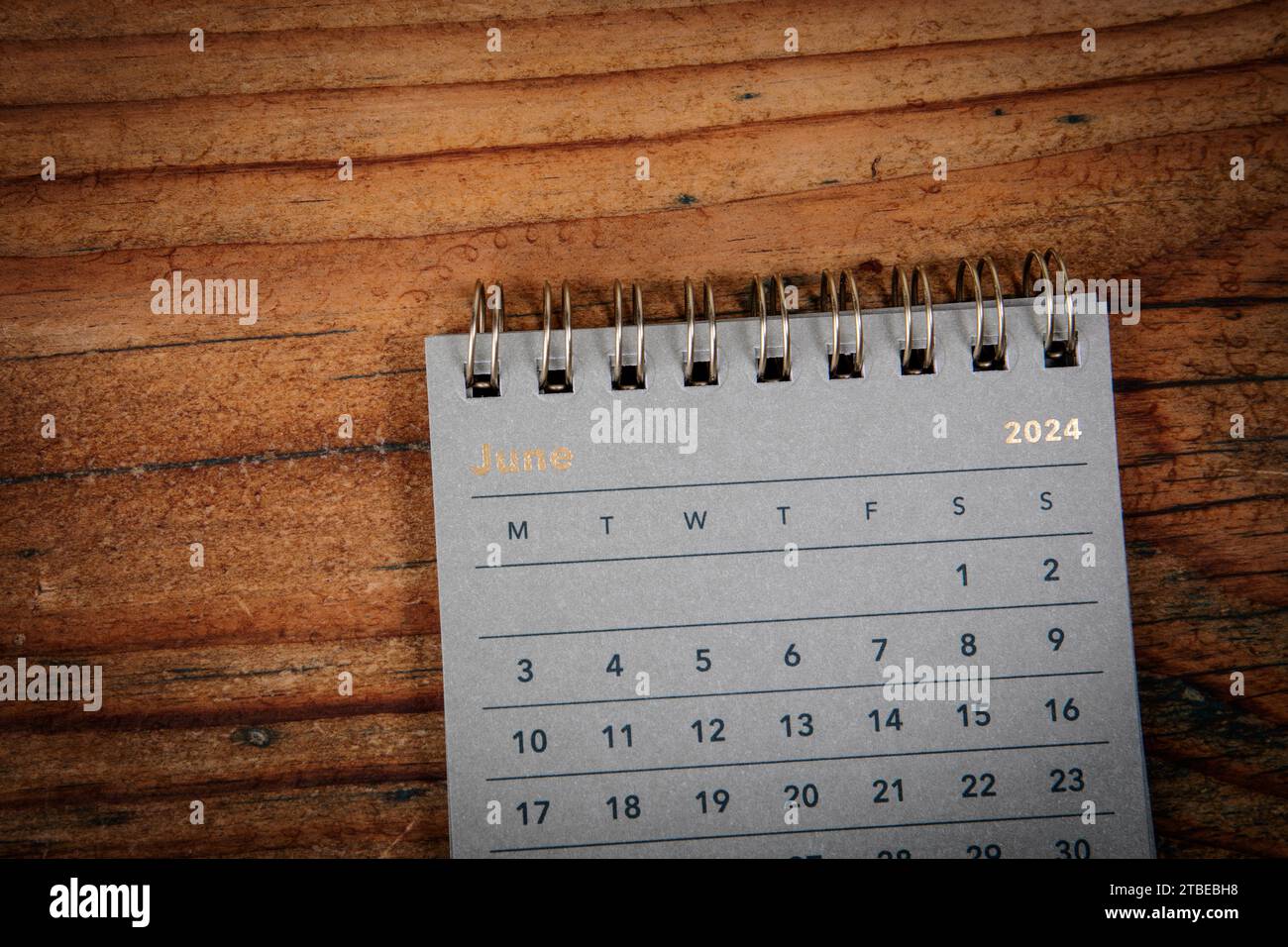 JUNE 2024. Green cardboard calendar on a wooden texture background ...