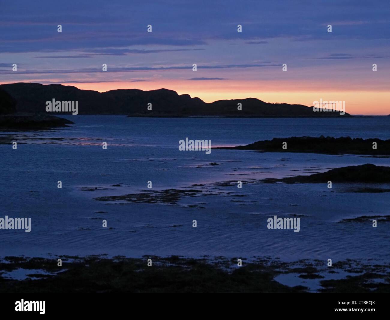 moody twilight image of indigo sea of hebridean bay at dusk with dark ...