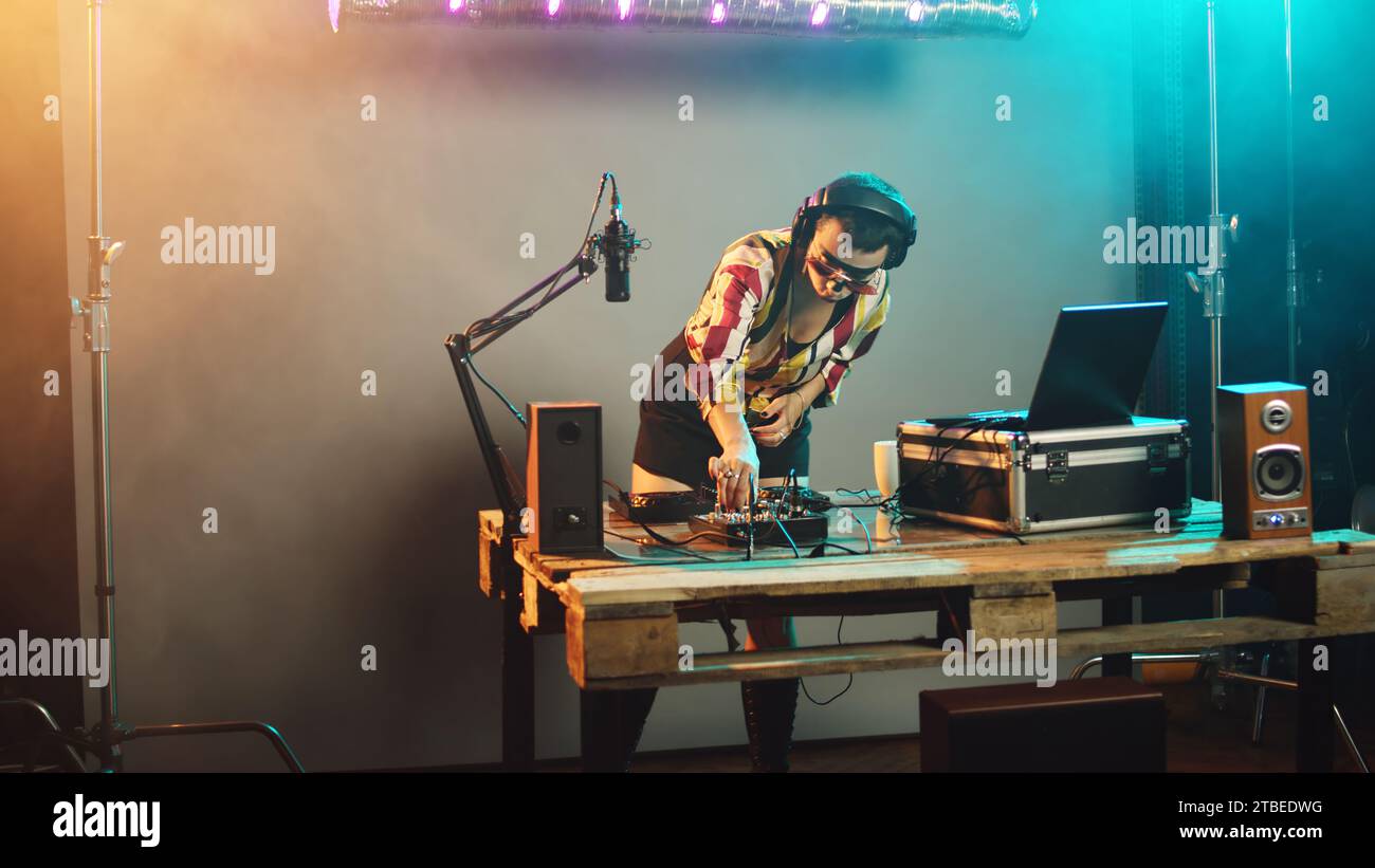 Sleepy dj woman yawning and trying to mix records at party, drinking ...
