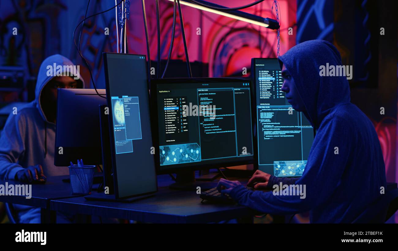 African american hacker and asian colleague working together in hidden ...