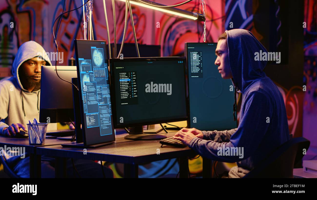 Asian hacker arriving in graffiti painted underground bunker, starting ...