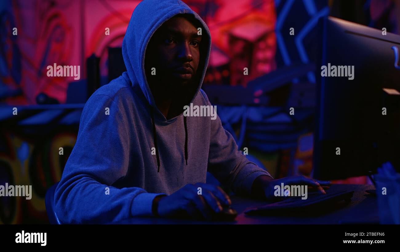 Hacker in secret dark room writing lines of code on computer ...