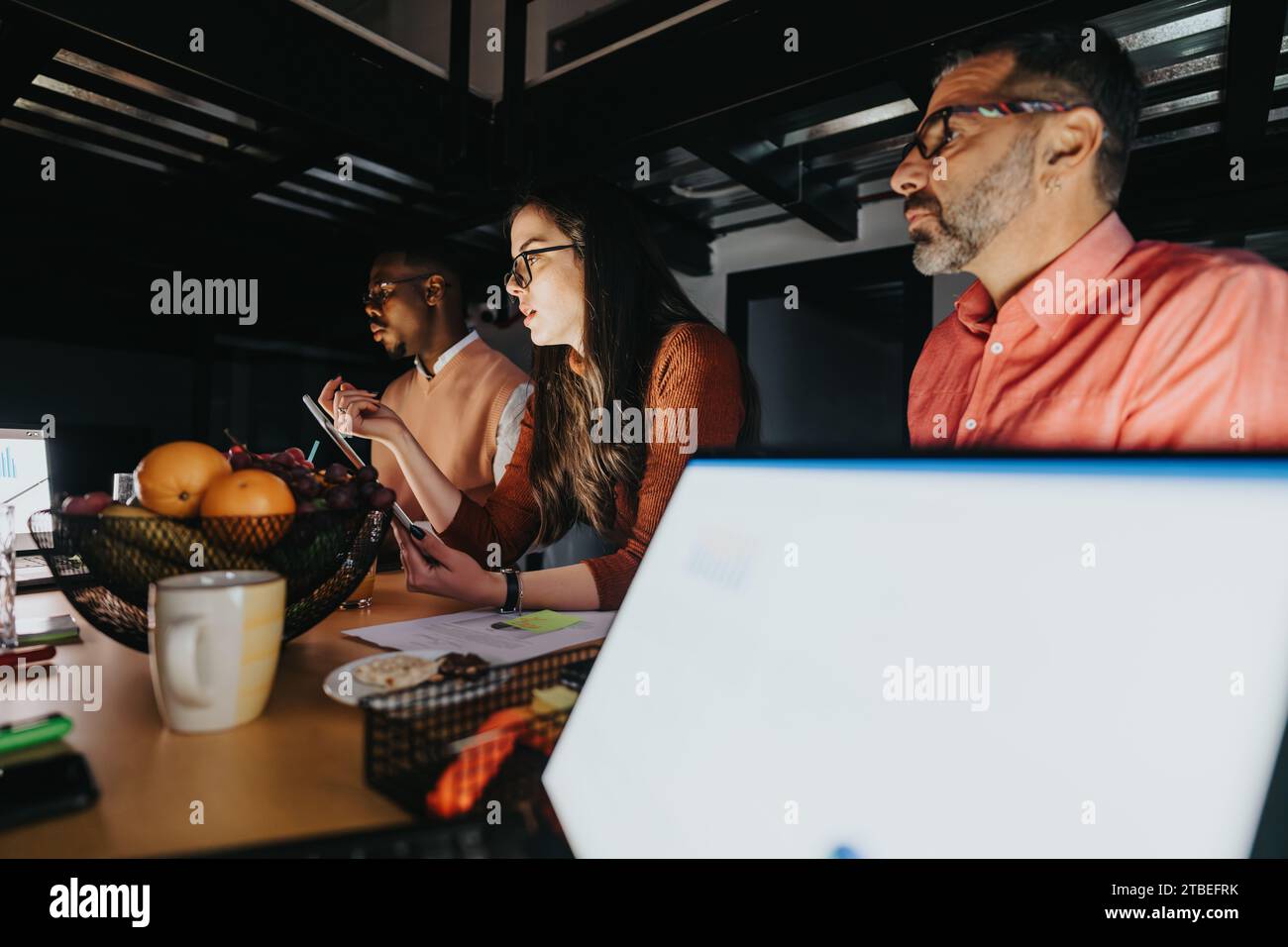 Late night collaboration of coworkers analyzing statistics, discussing ...