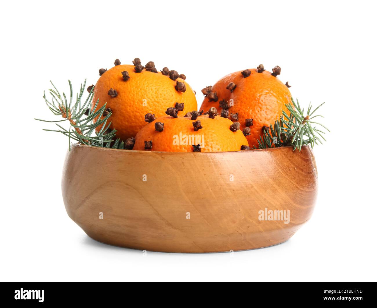 Wooden bowl with pomander balls and Christmas tree branches on white ...
