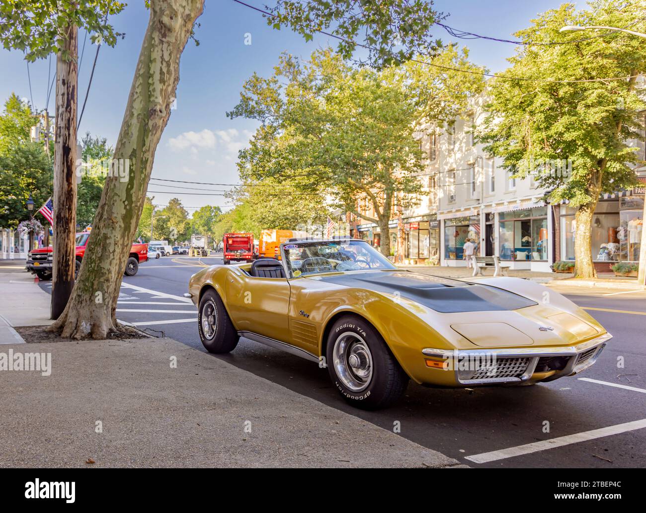 a vintage gold and black connvertible corvette parked on main street ...
