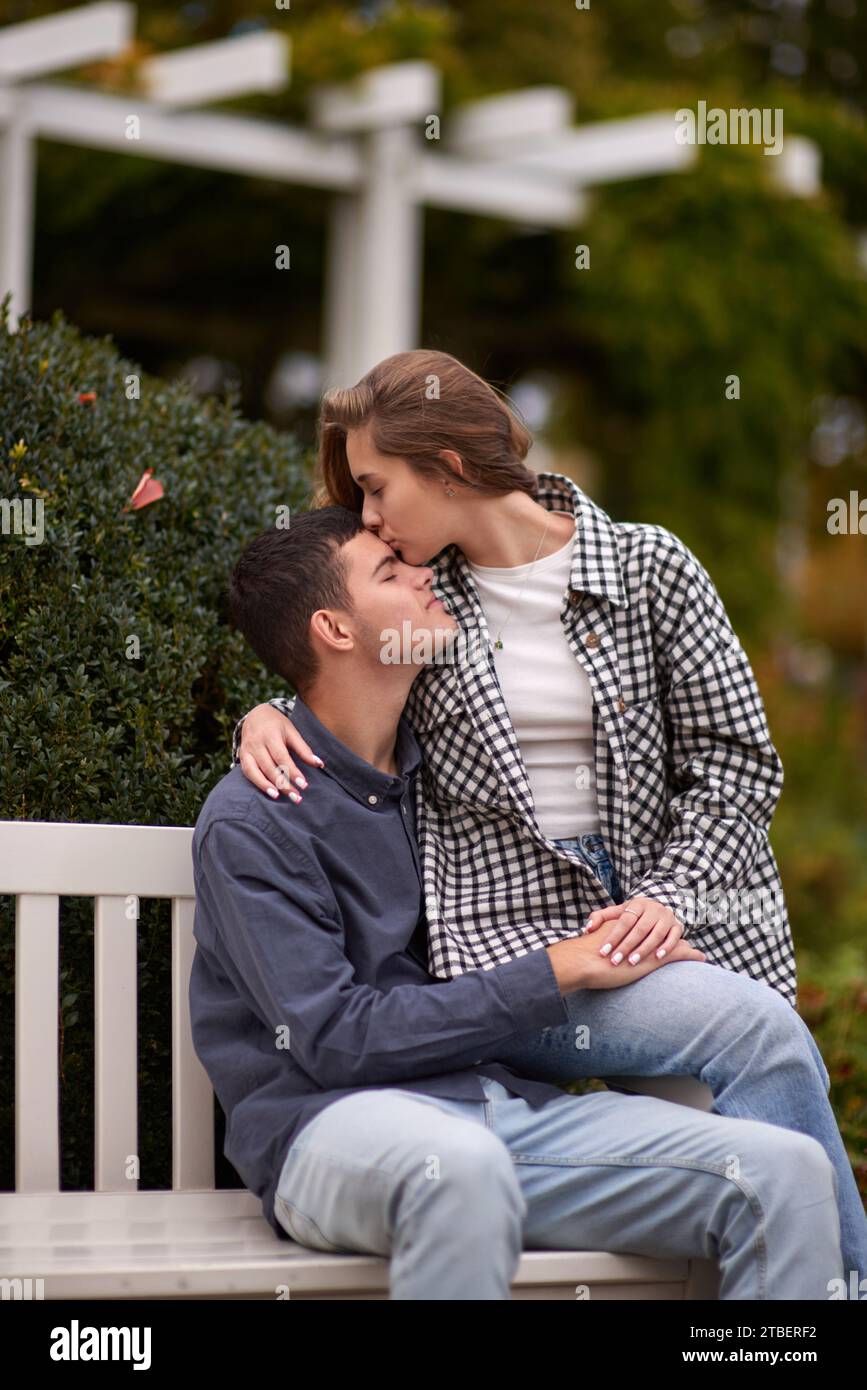 Autumn Romance: Young Couple Embracing and Kissing on Park Bench. Young ...