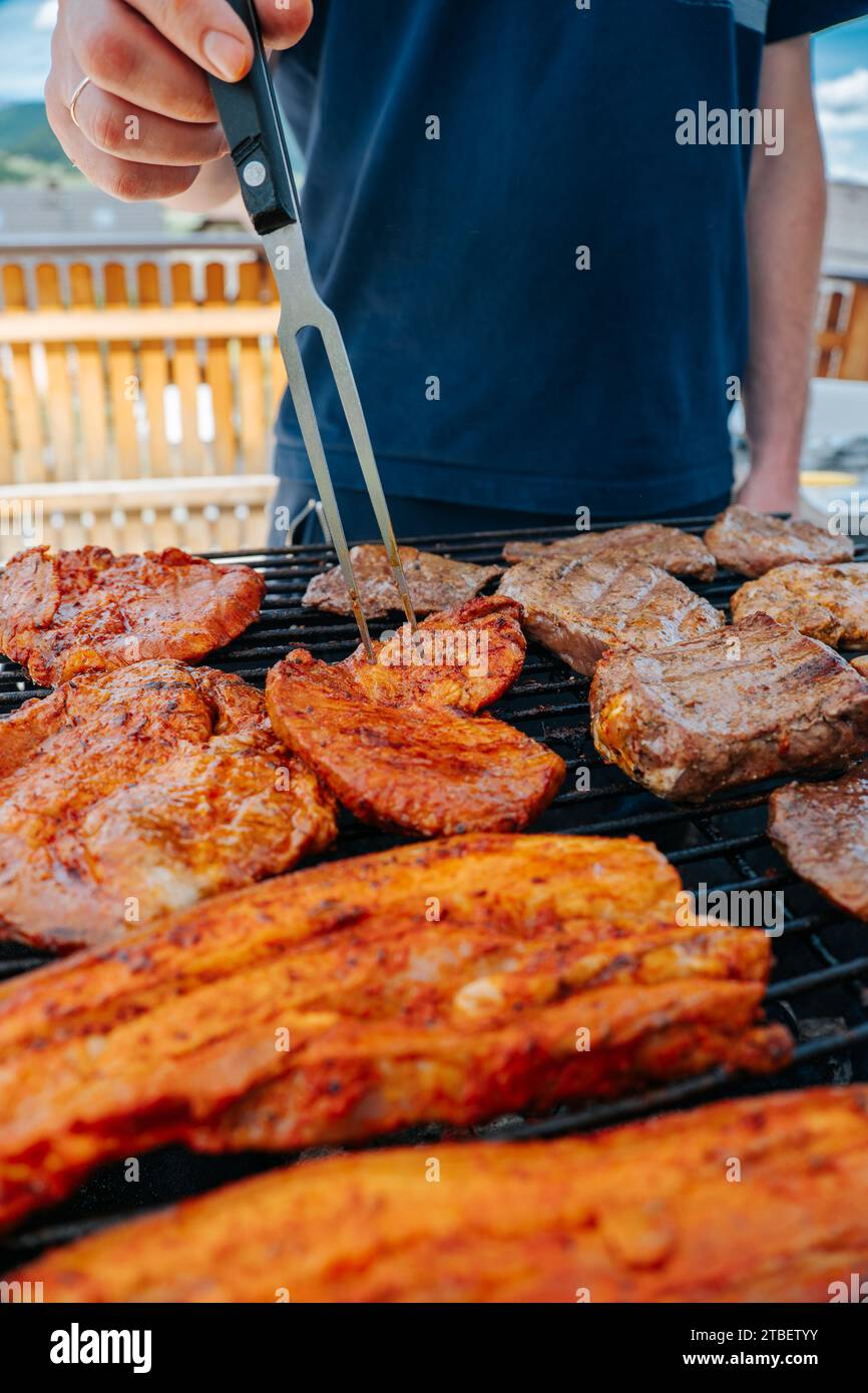 BBQ picnic. Grilled pork belly in marinade.Meat turns over on the grill ...