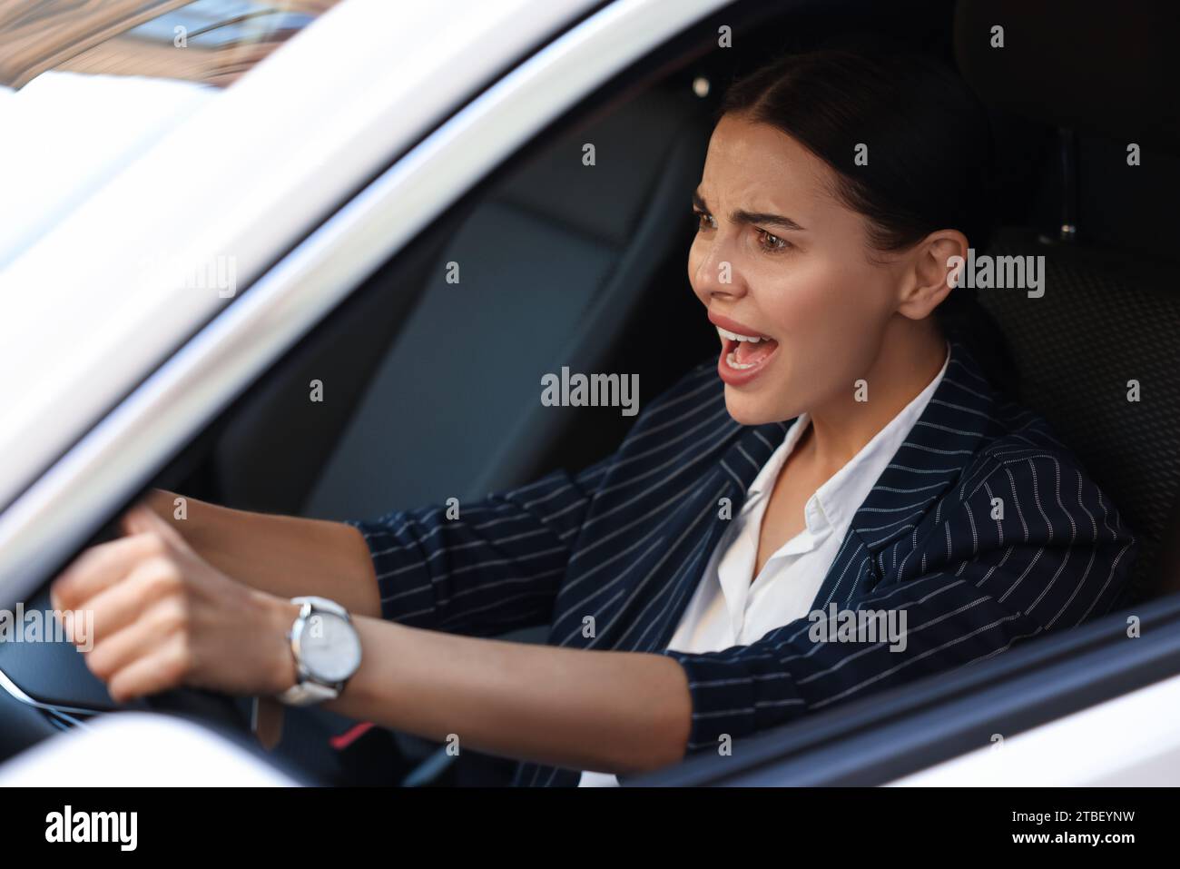 Angry driver screaming in her car, view from outside. Stuck in traffic ...