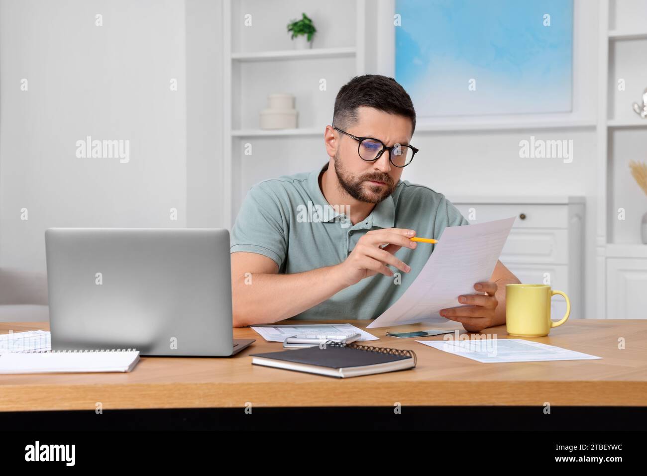 Man doing taxes at table in room Stock Photo - Alamy
