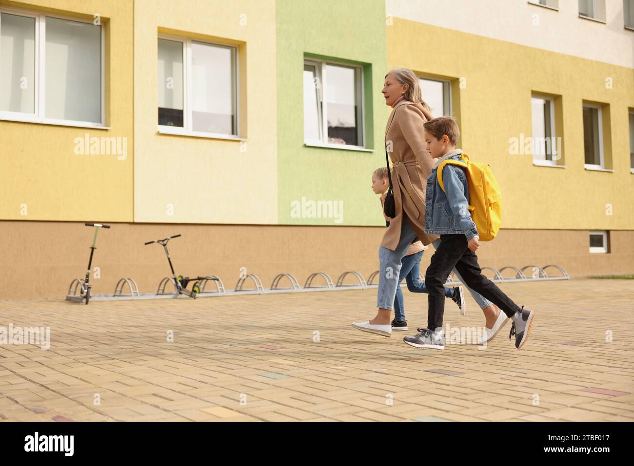 Being late for school. Senior woman and her grandchildren with ...