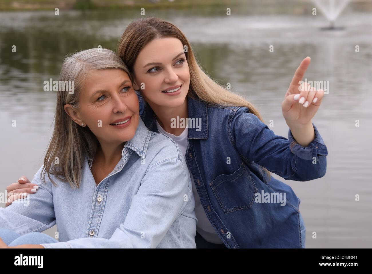 Happy mature mother and her daughter near pond Stock Photo - Alamy