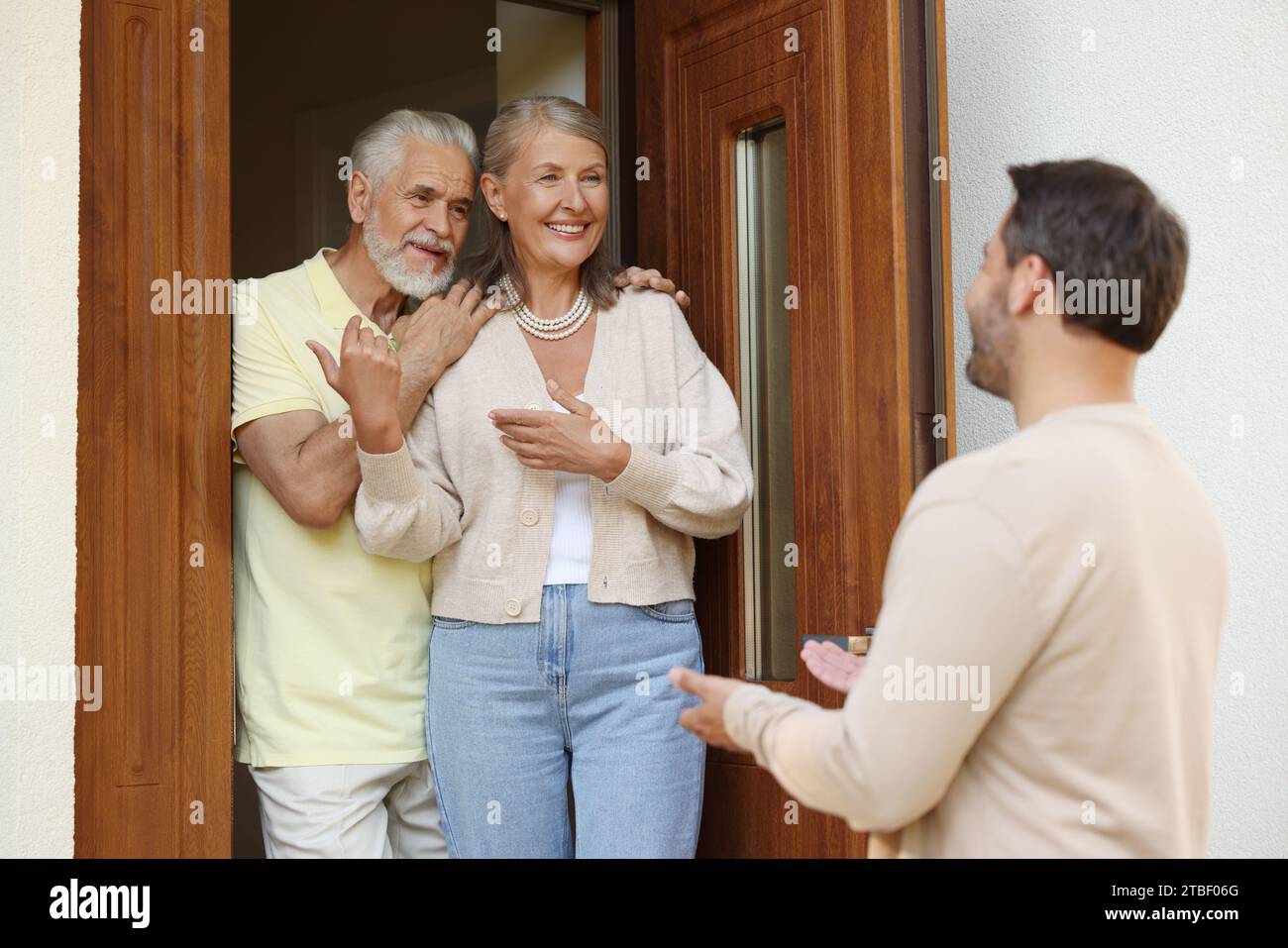 Friendly relationship with neighbours. Man visiting elderly couple ...