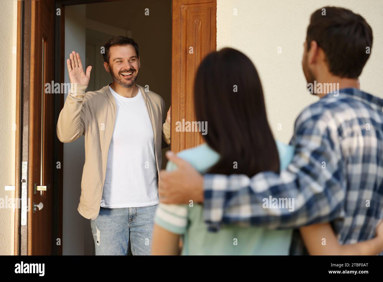 Friendly relationship with neighbours. Young couple visiting happy man ...