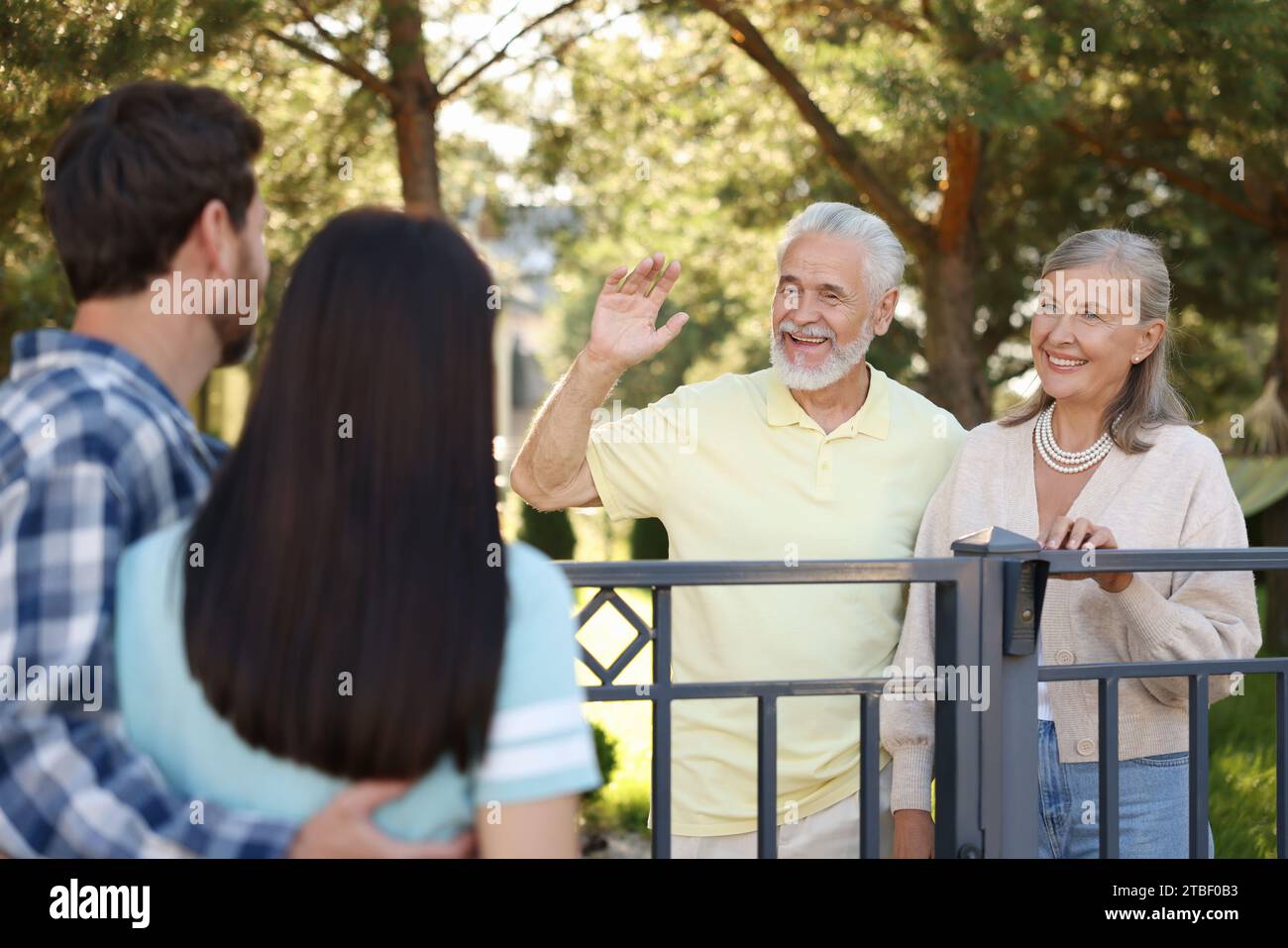 Friendly relationship with neighbours. Elderly couple greeting young ...