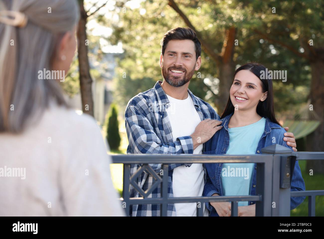Friendly relationship with neighbours. Happy young couple and senior ...