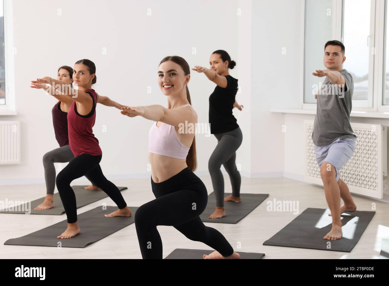 Group people practice warrior yoga hi-res stock photography and images ...